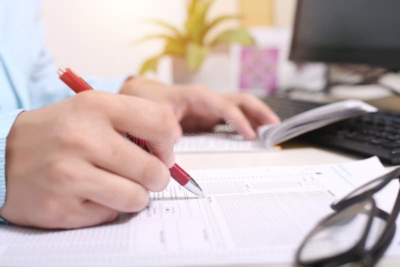 Man is Filling Paper Sheet with Pen. Picture of Computer, Keyboard ...