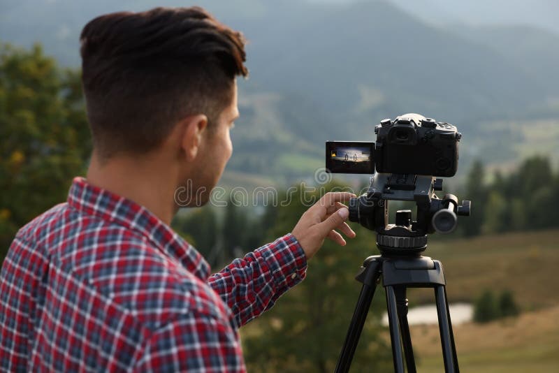 Man Filming Video with Modern Camera on Tripod Outdoors Stock Image ...