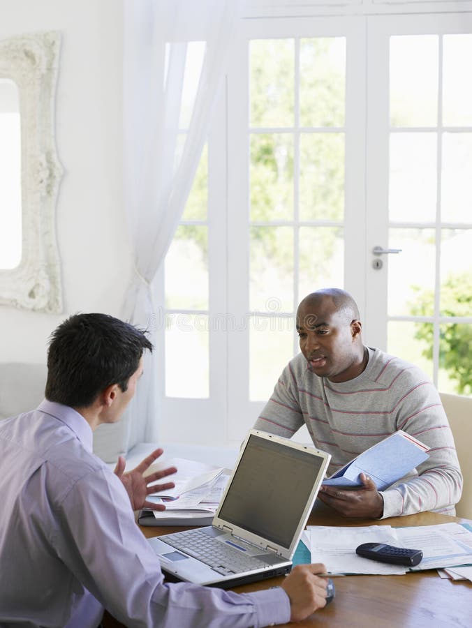 Man with Financial Advisor at Table Stock Photo - Image of document ...