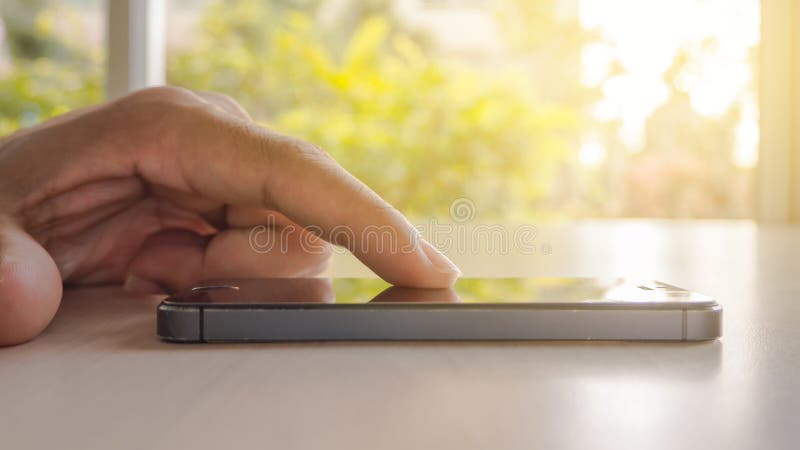 Man Finger Touching the Screen of a Smart-phone on the D Stock Image ...