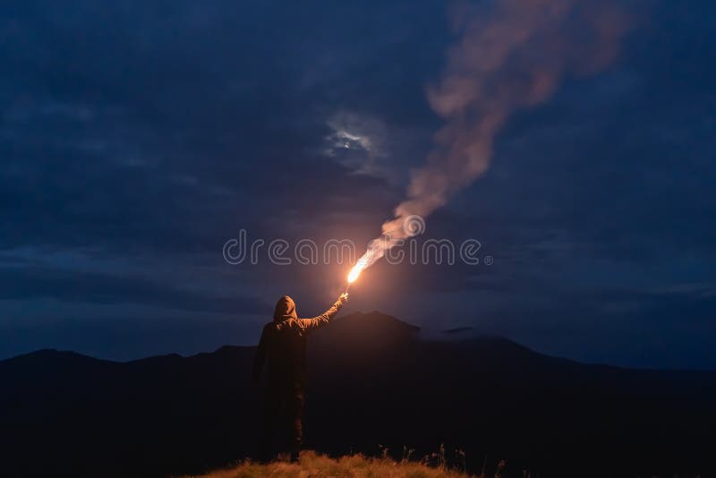 The Man with a Firework Stick Standing on a Mountain. Stock Photo ...