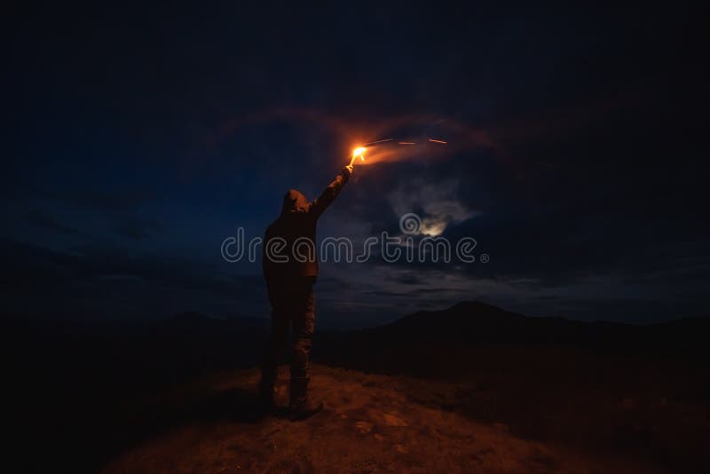 The Man with a Firework Stick Standing on the Night Mountain. Stock ...
