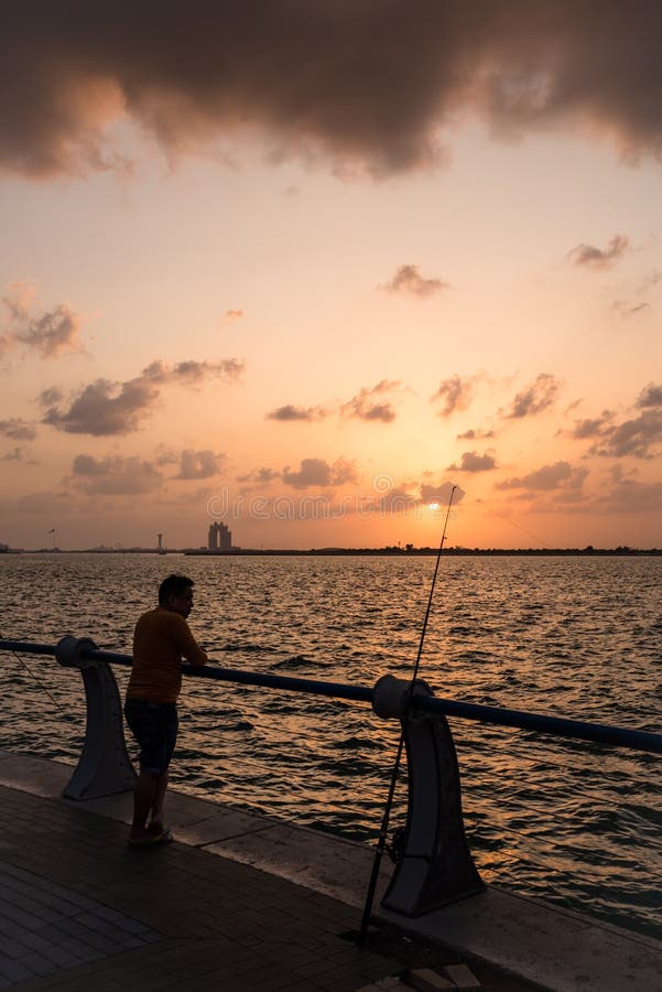 Man Fishing while Watching Sunset at Corniche Beach during Heavy Dark ...