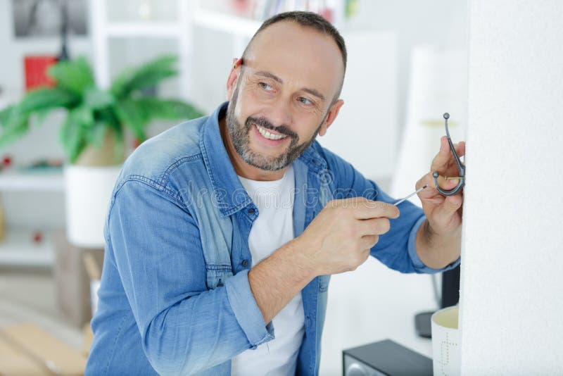 Man fitting hook on wall stock image. Image of hand - 263374207