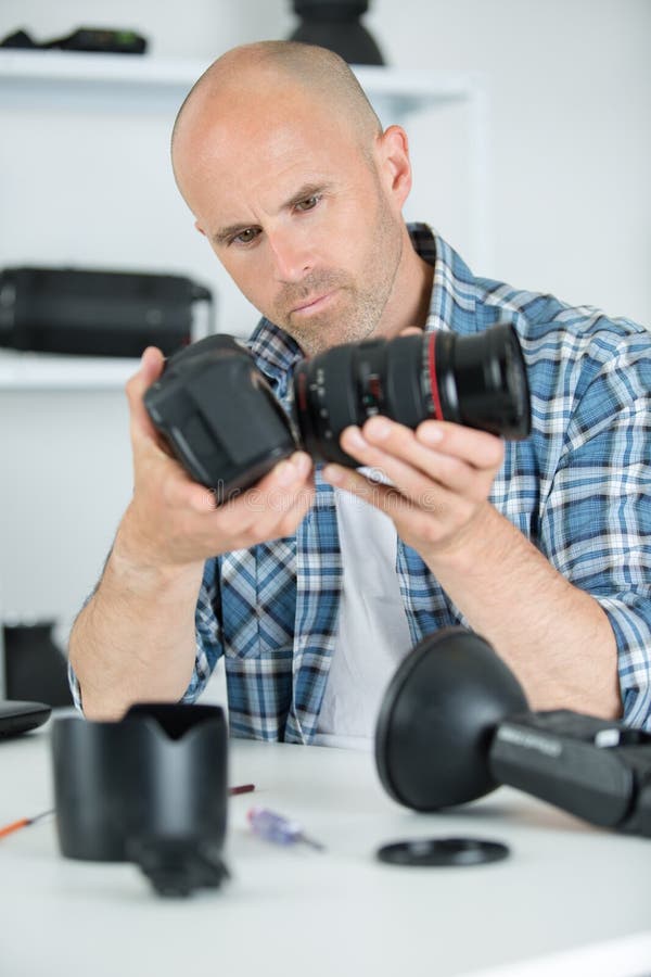 Man fitting lens to camera stock photo. Image of components - 123600408