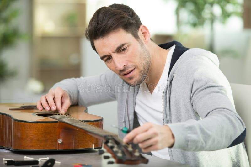 Man Fitting New String in Guitar Stock Image - Image of instrument ...