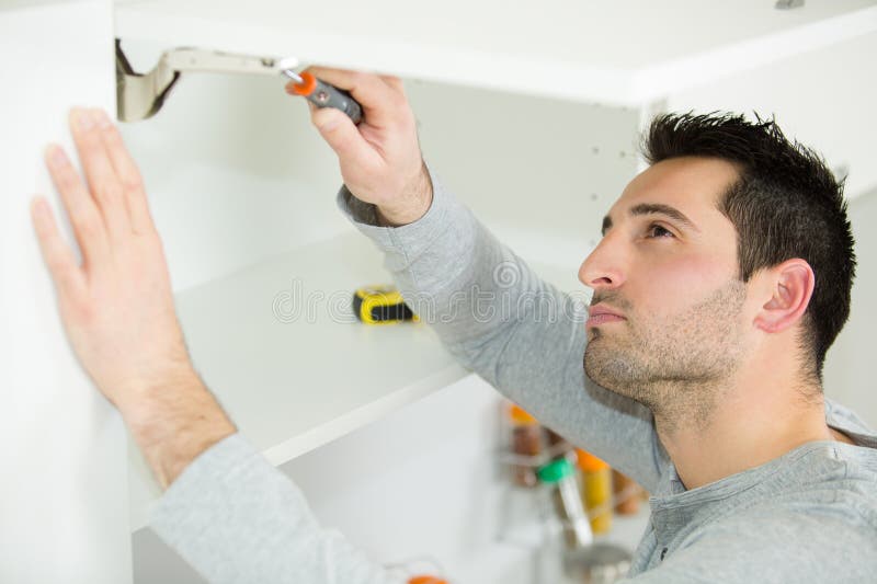 Man Fitting Overhead Kitchen Cupboard Stock Photo - Image of rebuild ...