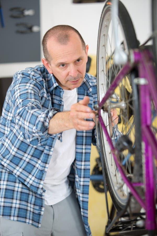 Man fixing bicycle over stock photo. Image of bicyclist - 99327956