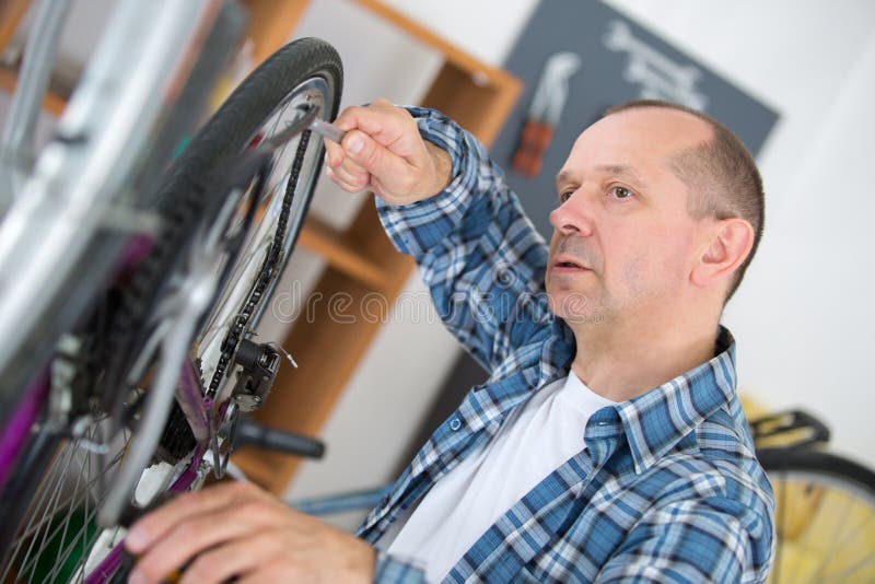 Man fixing a bike stock image. Image of health, handsome - 148695737
