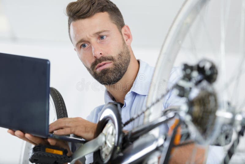 Man fixing bike stock photo. Image of tyre, standing - 226432158
