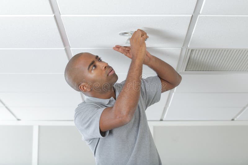 Man fixing ceiling light stock image. Image of replacement - 286823631
