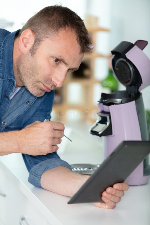 Man fixing coffee machine stock photo. Image of hardware - 264498788