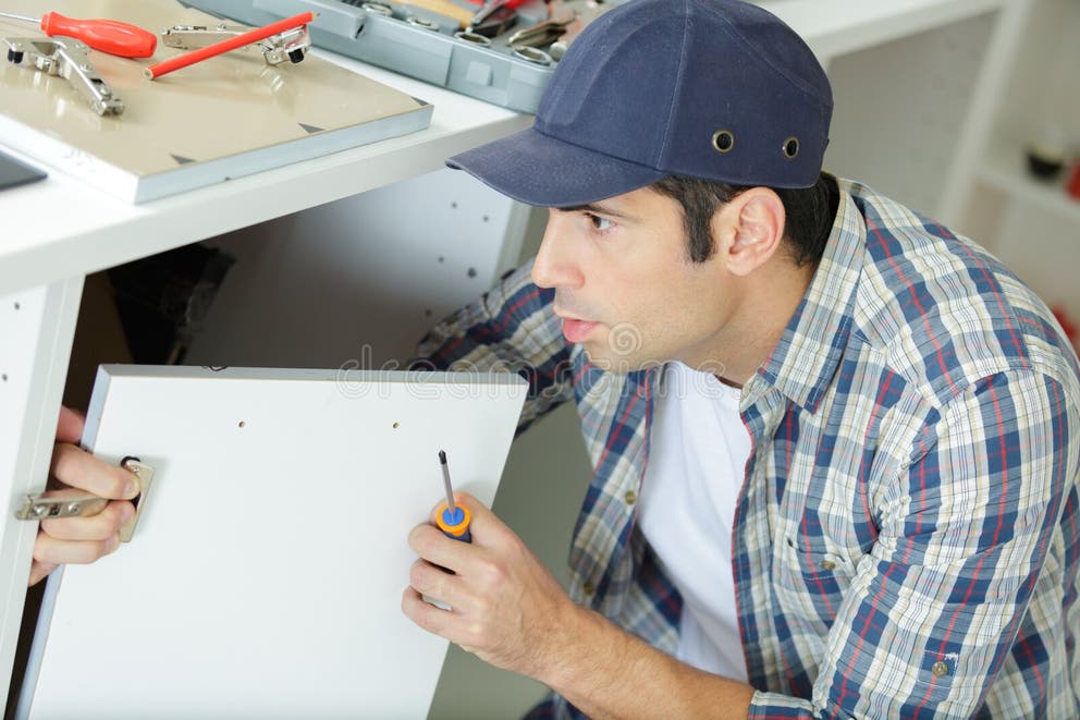 Man fixing cupboard stock photo. Image of homeimprovement - 311726370