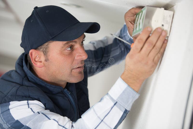 Man Fixing Exit Sign To Wall Stock Image - Image of professional, left ...