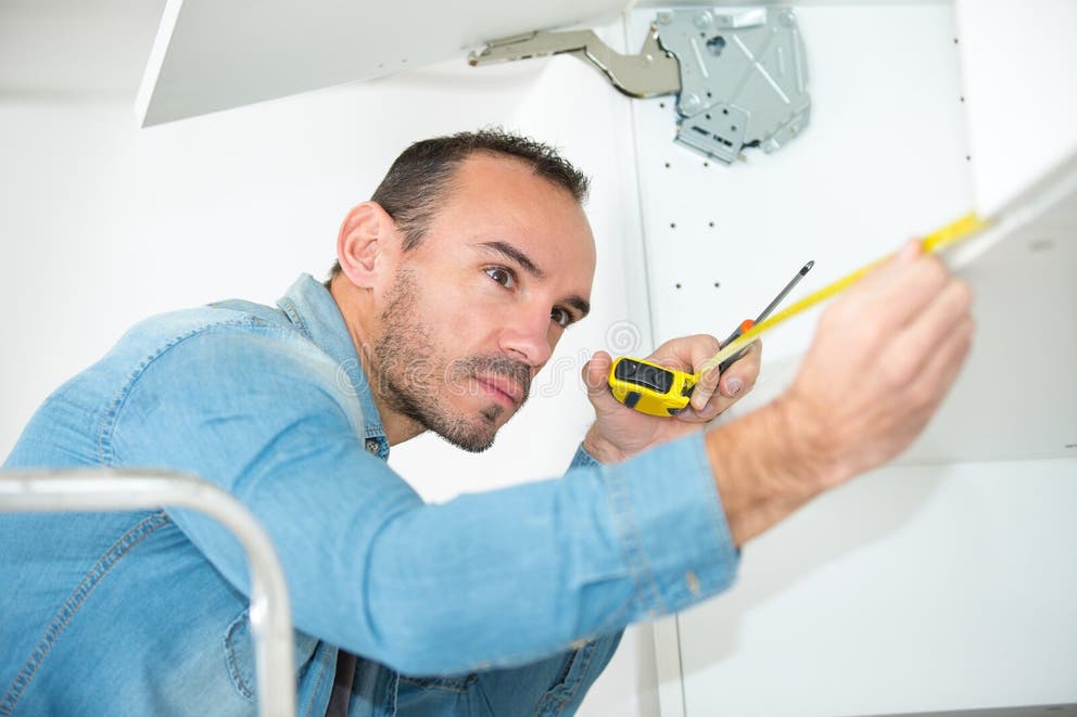 Man Fixing or Fitting Cupboard in Kitchen Stock Photo - Image of ...