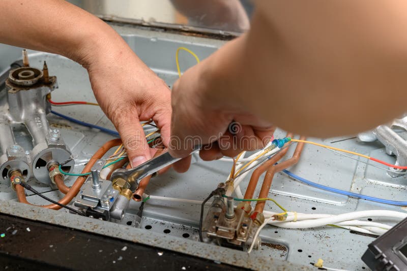 A man fixing a gas cooker stock image. Image of service - 192499503