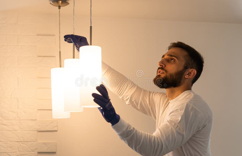 Man Fixing Light at Home. stock image. Image of white - 258723701