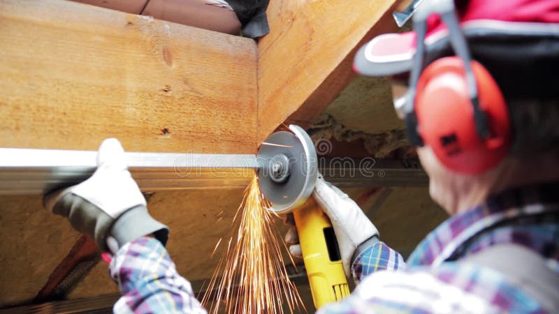 Man Fixing Metal Frame Using Angle Grinder on Attic Ceiling Covered ...