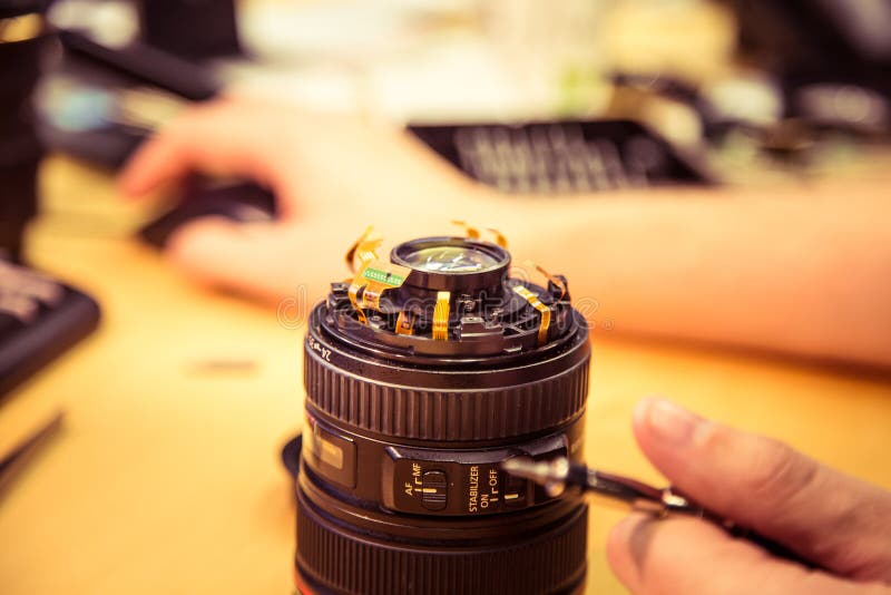 A Man Fixing Photo Camera Lens on an Office Table Stock Photo - Image ...