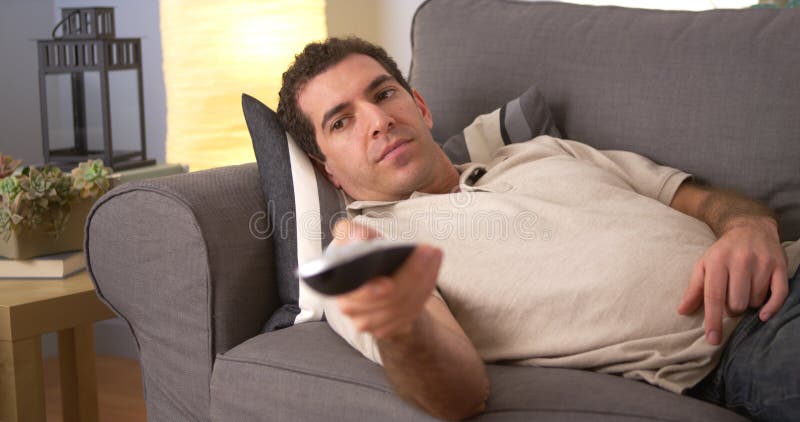 Man Flipping through Channels on Couch Stock Image - Image of changing ...