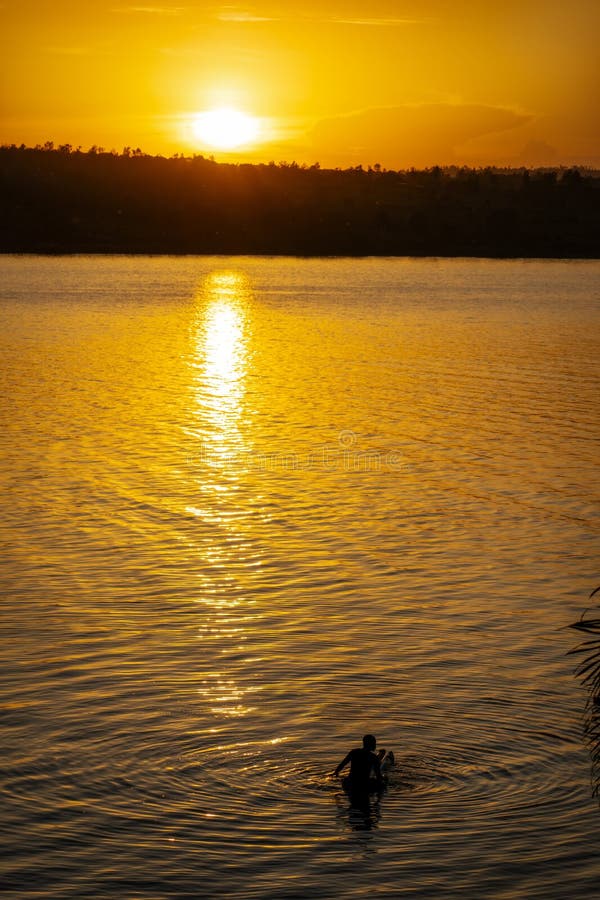 Man Floating on a Tree Log in Rwanda Stock Photo - Image of dock ...