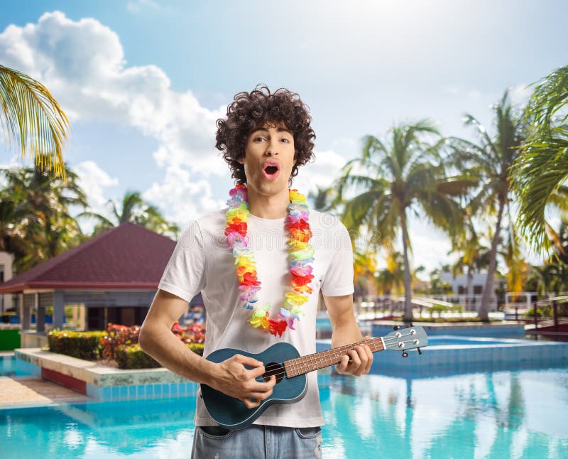 Man with Flower Chain Around Neck Playing Ukulele by a Pool Stock Image ...