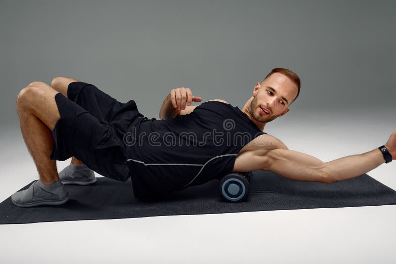 Man Foam Rolling. Athlete Stretches Using Foam Roller. Stock Image ...