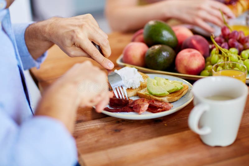Man with Fork Eating Bacon at Table Full of Food Stock Image - Image of ...