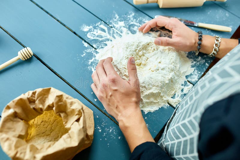 Man Forming the Dough on a Floured Surface and Kneading it with His ...