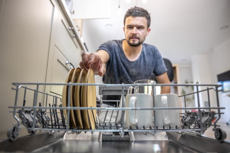 The Man Takes Clean Plates from the Dishwasher Stock Photo - Image of ...