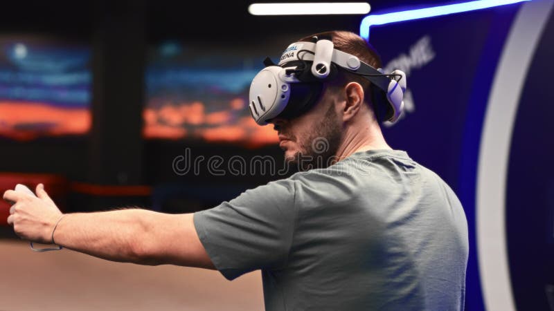 Man Fully Immersed in VR Shooter Game at Virtual Reality Lounge ...