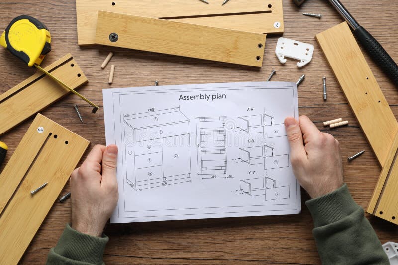 Man with Furniture and Assembly Plan at Wooden Table, Top View Stock ...