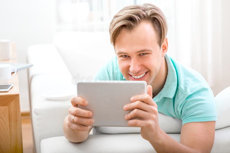 Man with Gadget Sitting at Home Stock Photo - Image of play, laying ...