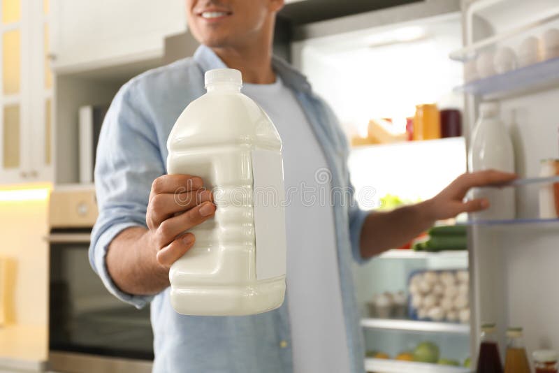 Man with Gallon of Milk Near Refrigerator in Kitchen, Closeup Stock ...