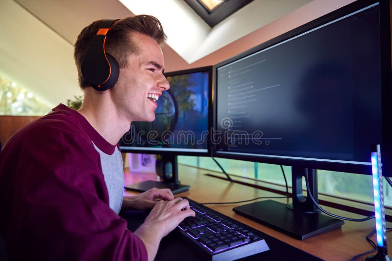 Man Gaming at Home Sitting at Desk with Multiple Monitors Stock Photo ...