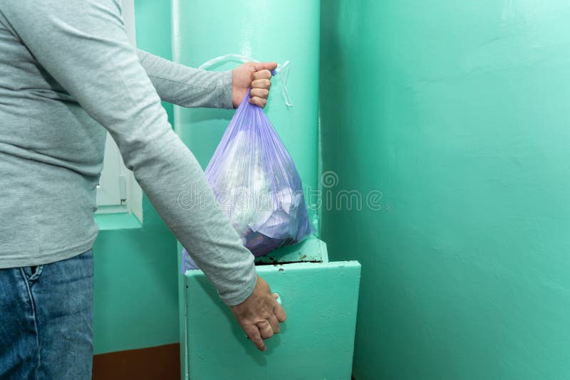 A Man with a Garbage Bag Opens the Hatch of the Garbage Chute and ...