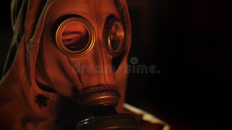 A Man in a Gas Mask Looks at the Fire, the Flame is Reflected in the ...