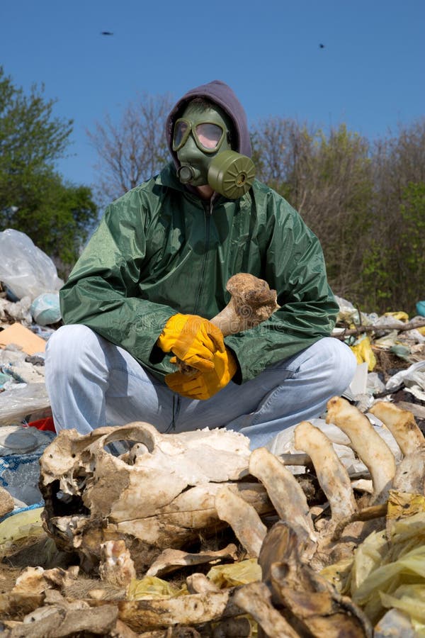 Man in a Gas Mask Sitting on the Garbage and Holding a Bone Stock Image ...