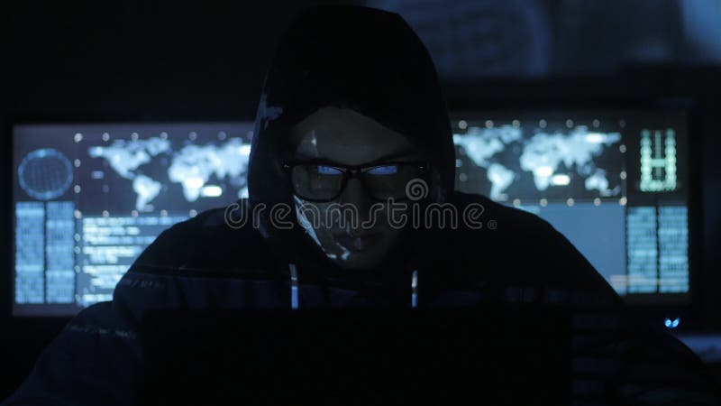 Man Geek Hacker In Hood With Glasses Working At Computer While Blue