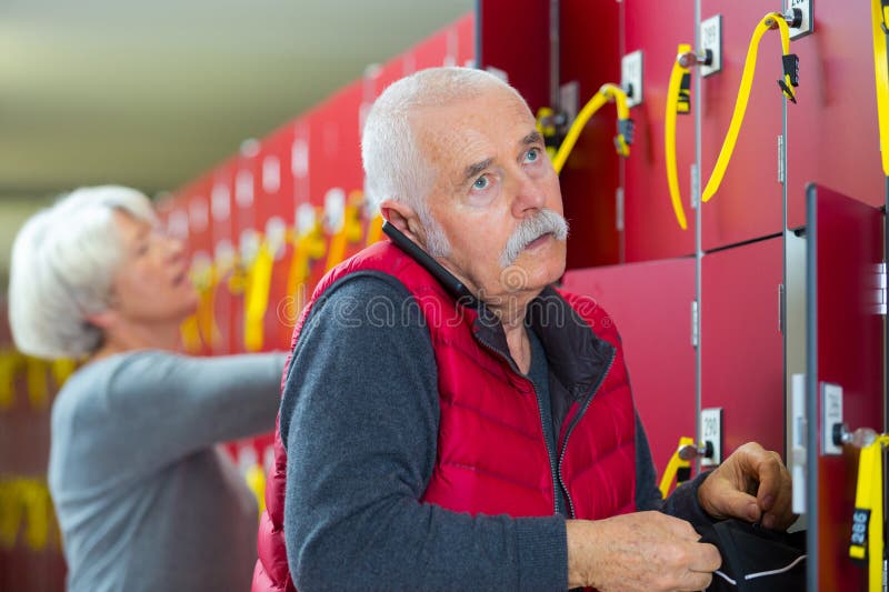 Man Getting Bag from Locker with Smartphone Balanced on Shoulder Stock ...