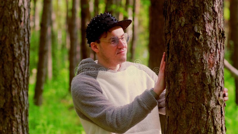 Man in Glasses, Cap Looking at Tree, Touching it, Standing in Forest ...