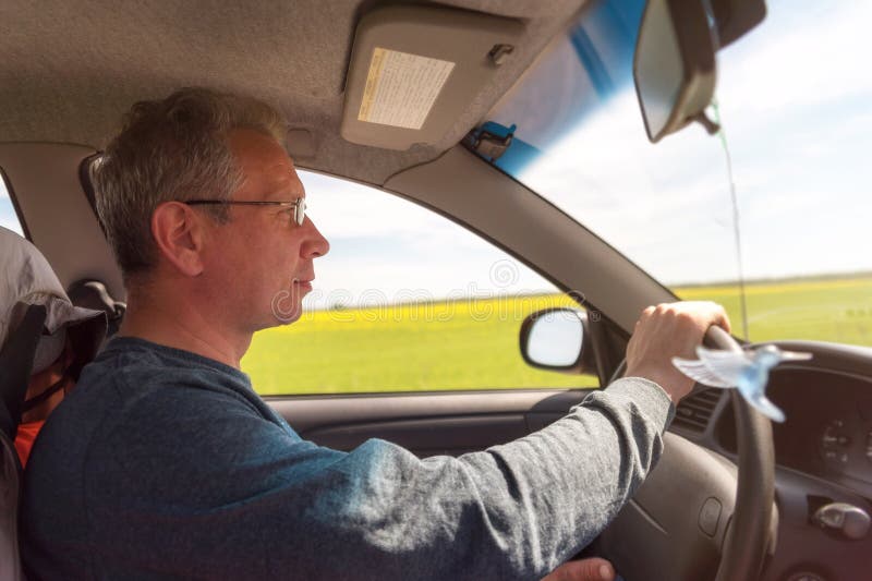 A Man with Glasses Driving a Car. the Driver Drives the Car Stock Photo ...
