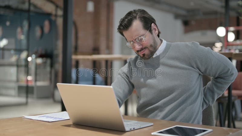 Young Man Having Back Pain while Using Laptop in Office Stock Video ...