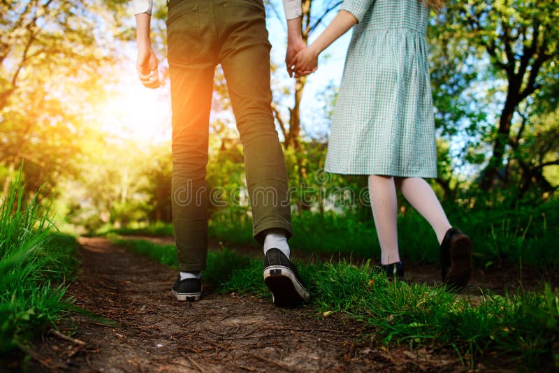 Man Goes with His Girlfriend on the Road, Low Angle, Back View Stock ...