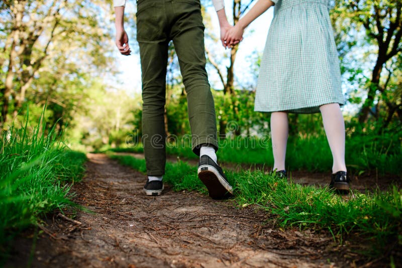 Man Goes with His Girlfriend on the Road, Low Angle, Back View Stock ...