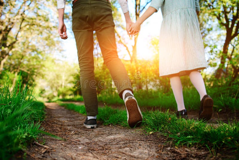 Man Goes with His Girlfriend on the Road, Low Angle, Back View Stock ...