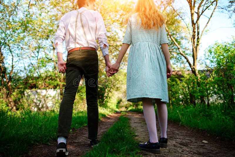 Man Goes with His Girlfriend on the Road, Low Angle, Back View Stock ...