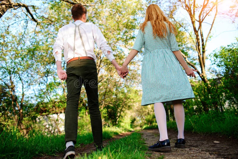 Man Goes with His Girlfriend on the Road, Low Angle, Back View Stock ...