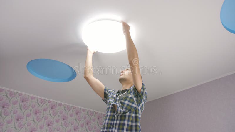 A Man Installs a Modern Led Ceiling Light on the Ceiling. Stock Video ...