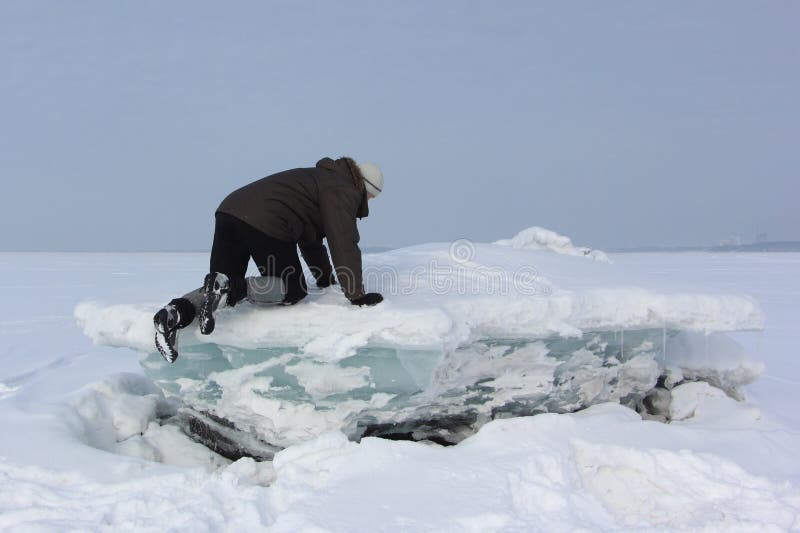 The Man in a Gray Cap Moving Along the Ice Block on the River Stock ...